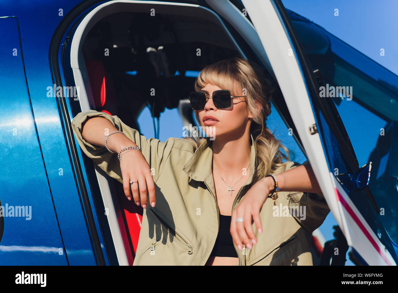 Female pilot in cockpit of helicopter before take off. Young woman ...