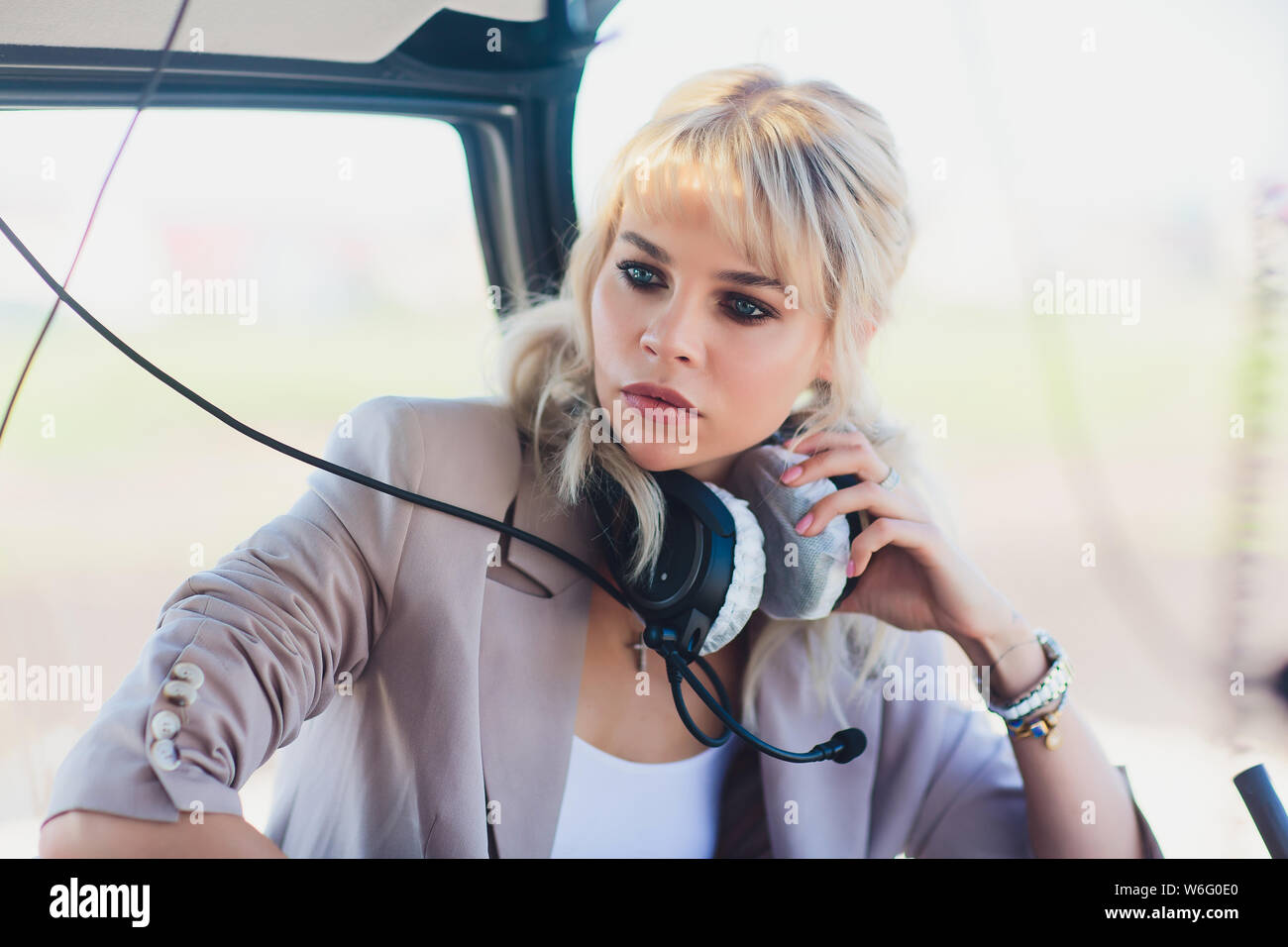 Female pilot in cockpit of helicopter before take off. Young woman ...