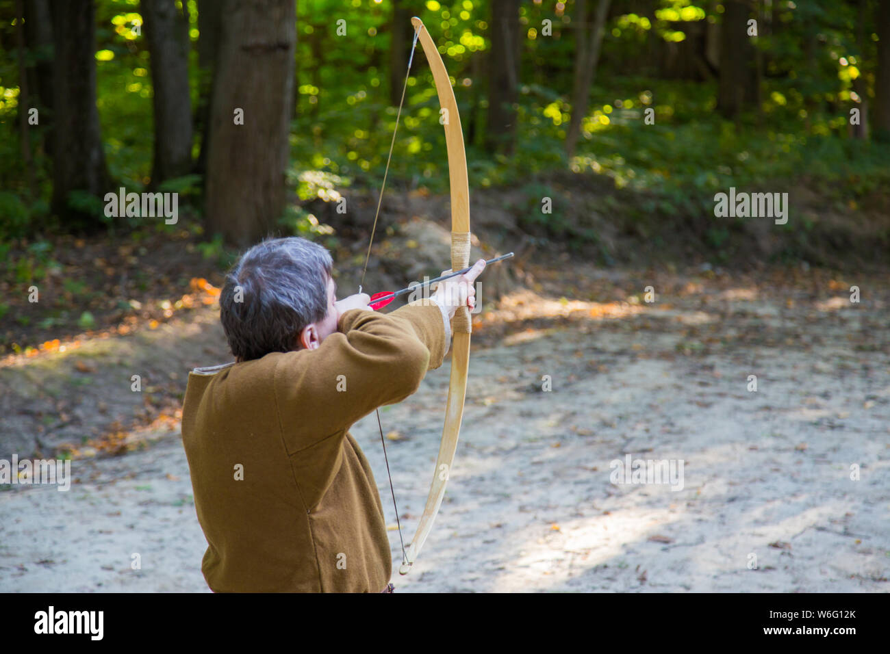 Male archer with wooden bow Stock Photo - Alamy