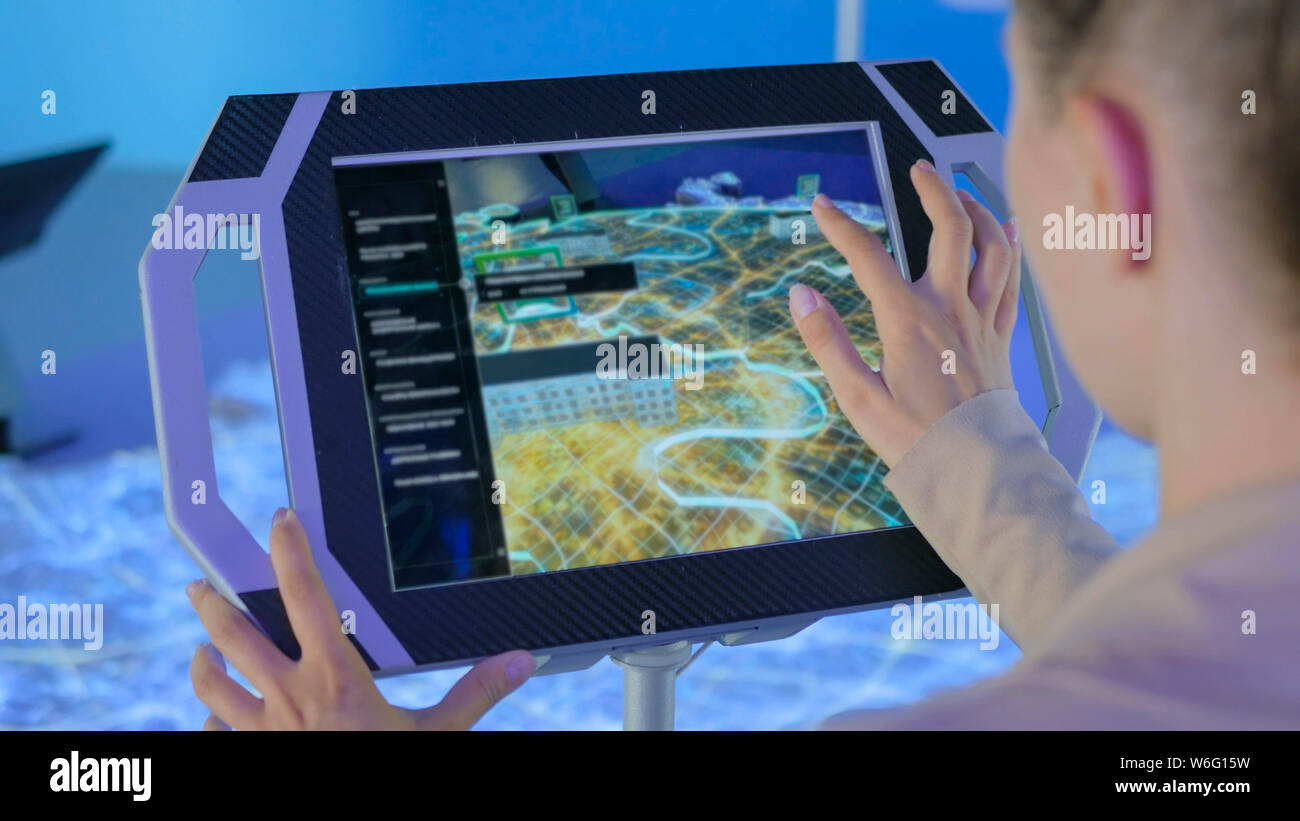 Woman using interactive touchscreen display at modern technology ...