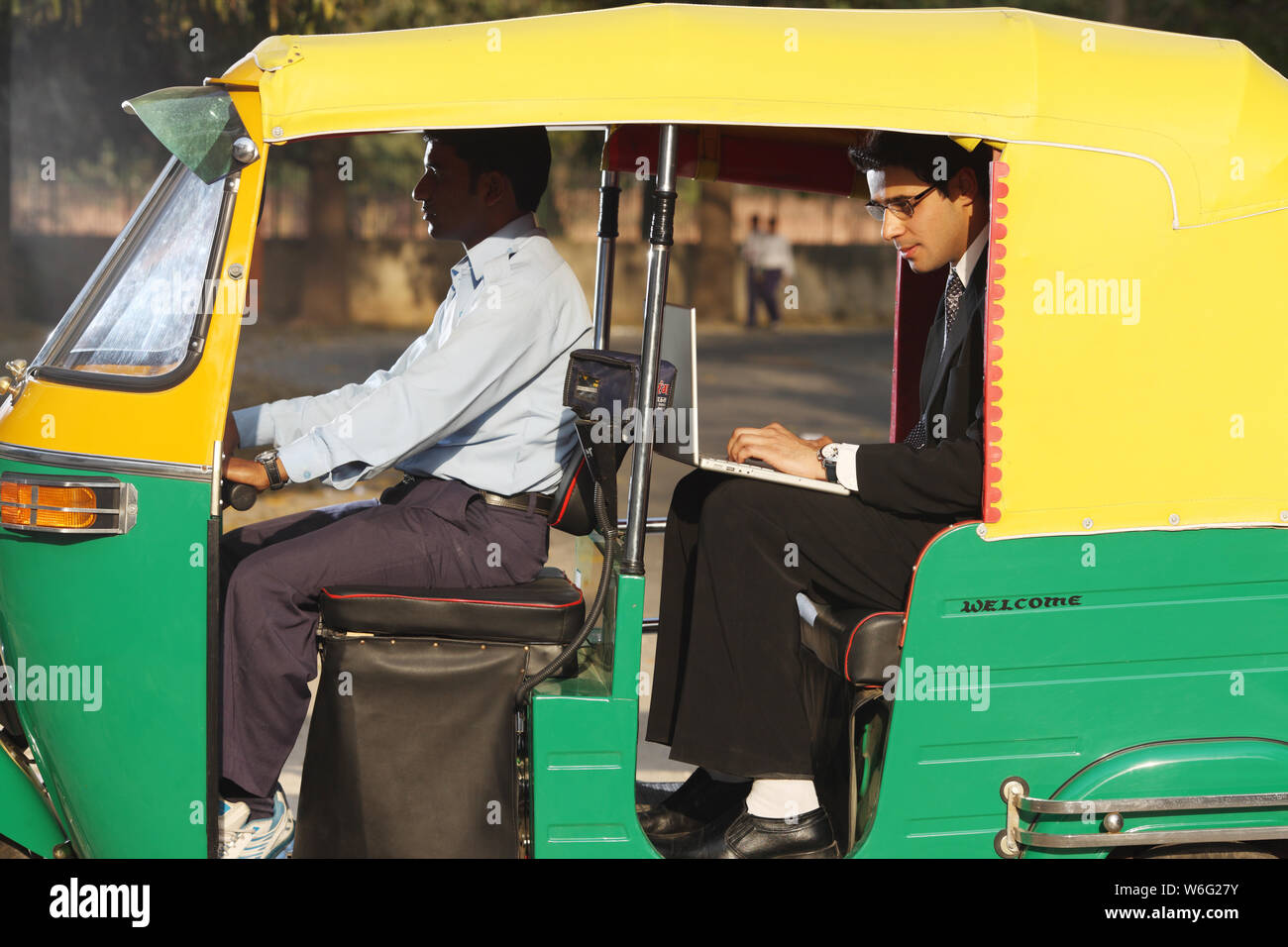 Businessman using laptop in an auto rickshaw Stock Photo - Alamy