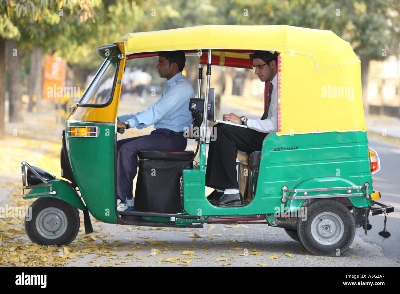 Businessman using laptop in an auto rickshaw Stock Photo - Alamy