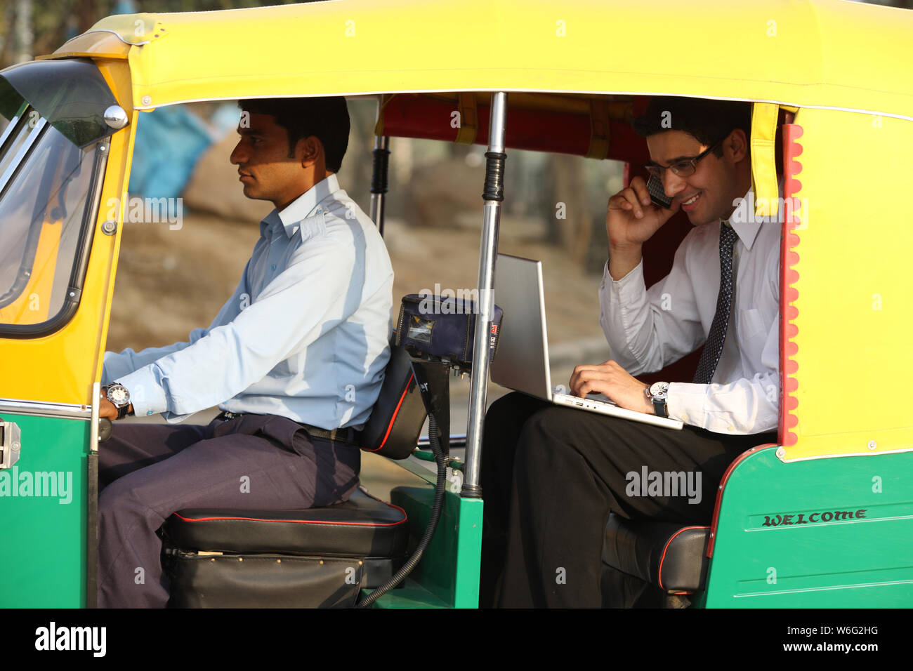 Businessman using laptop in an auto rickshaw Stock Photo - Alamy