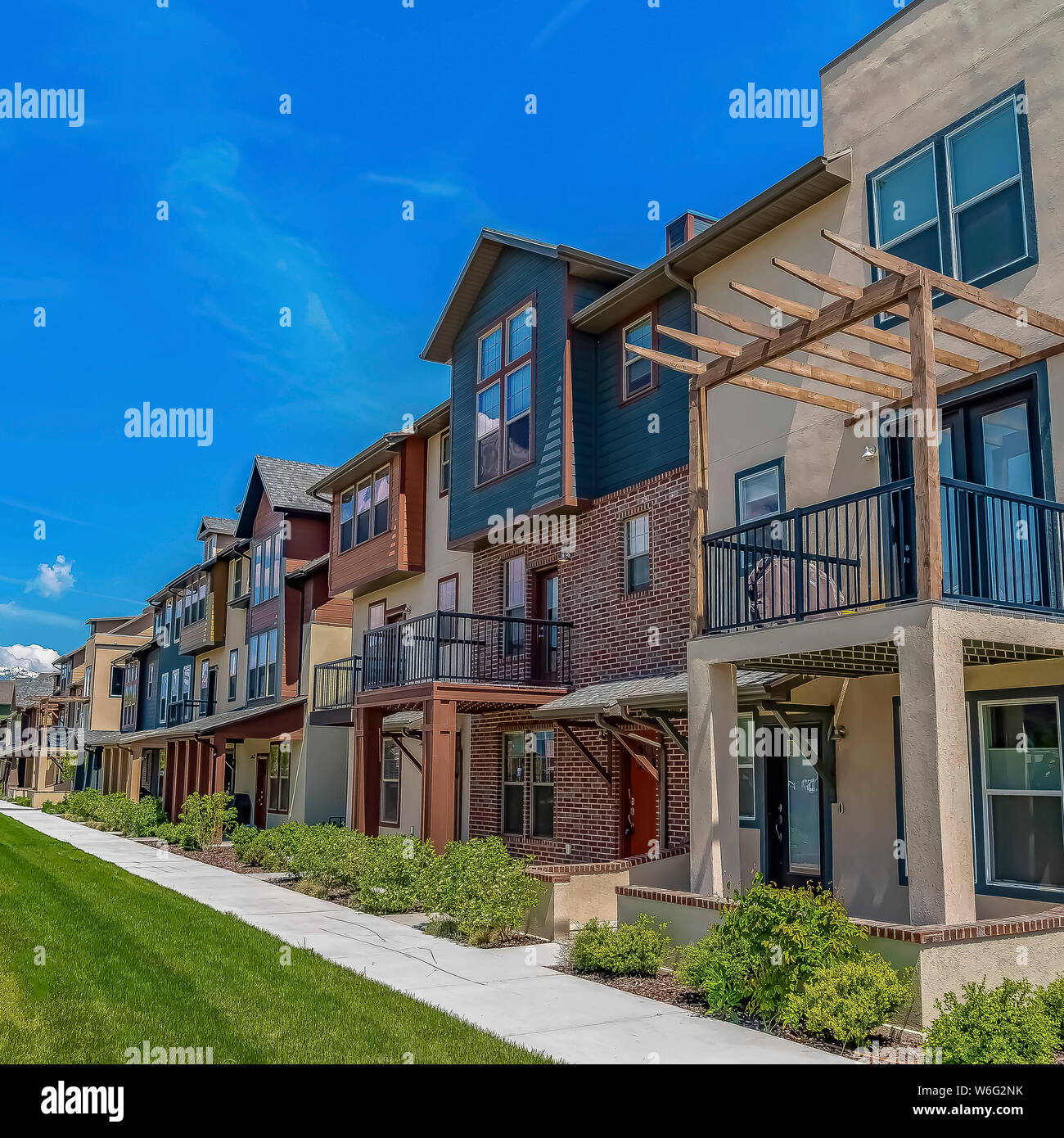 Square frame Row of homes with porches and small balconies under blue ...