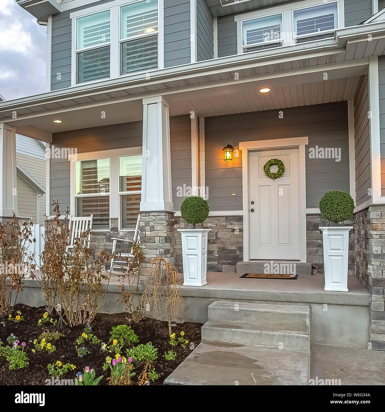 Square frame Porch and yard at the facade of a home with stairs leading ...