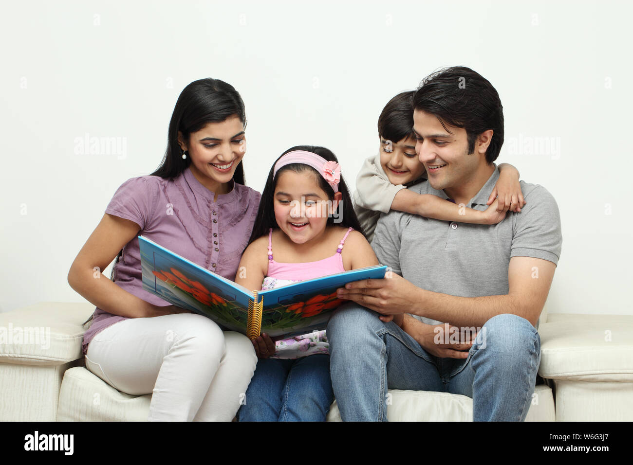 Family looking at family photo album Stock Photo - Alamy