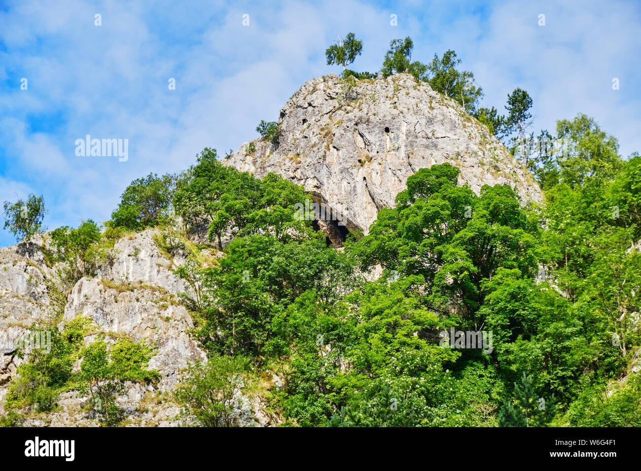 High rock wall with cave, where multi-pitch climbing routes and via ...
