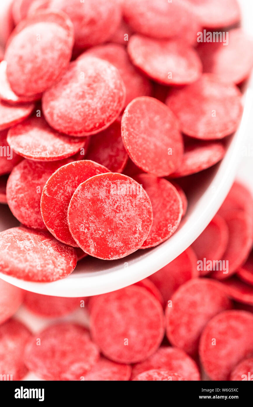 Red round chocolate chips for melting chocolate shapes on a white ...