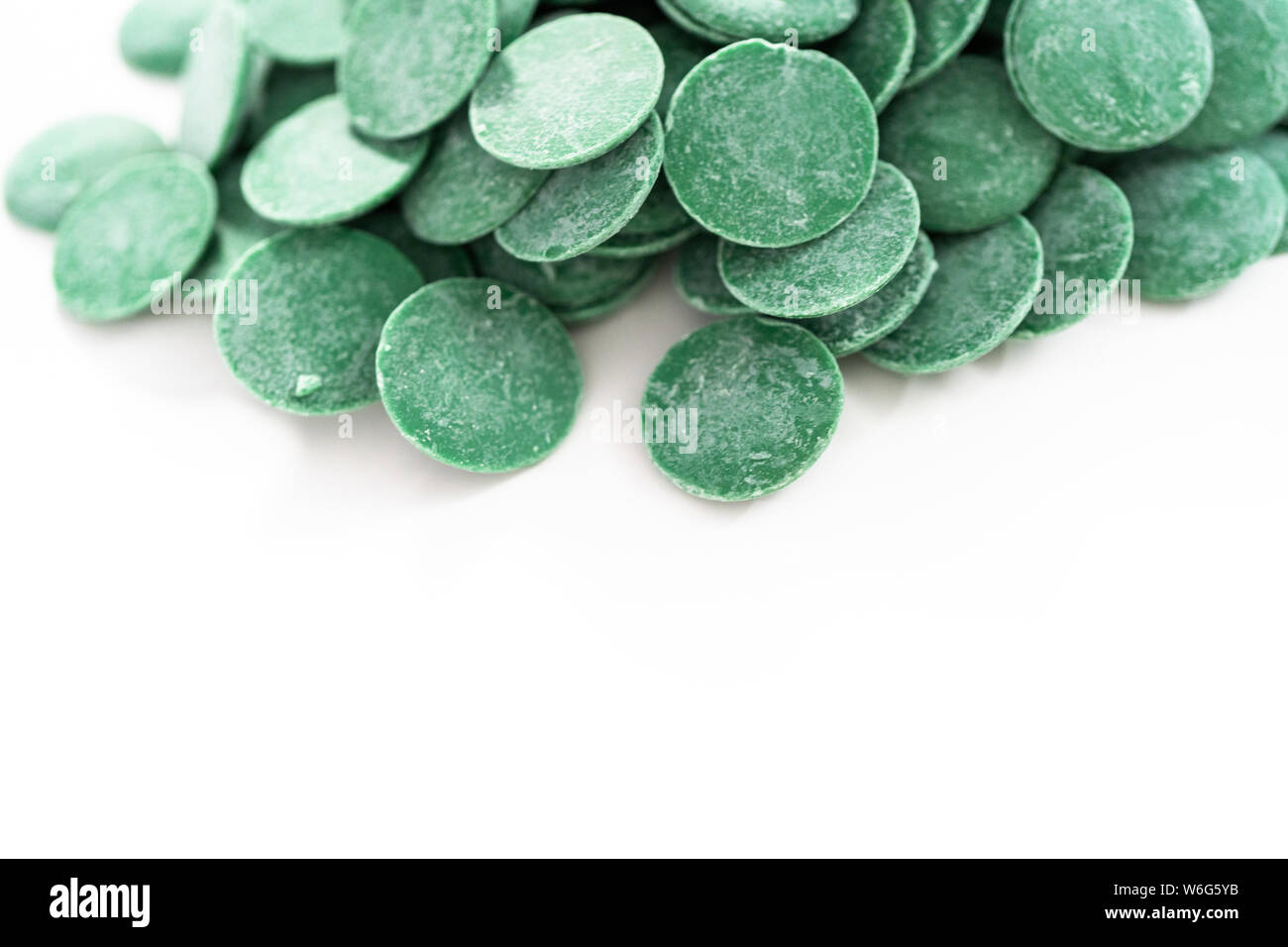 Green round chocolate chips for melting chocolate shapes on a white ...