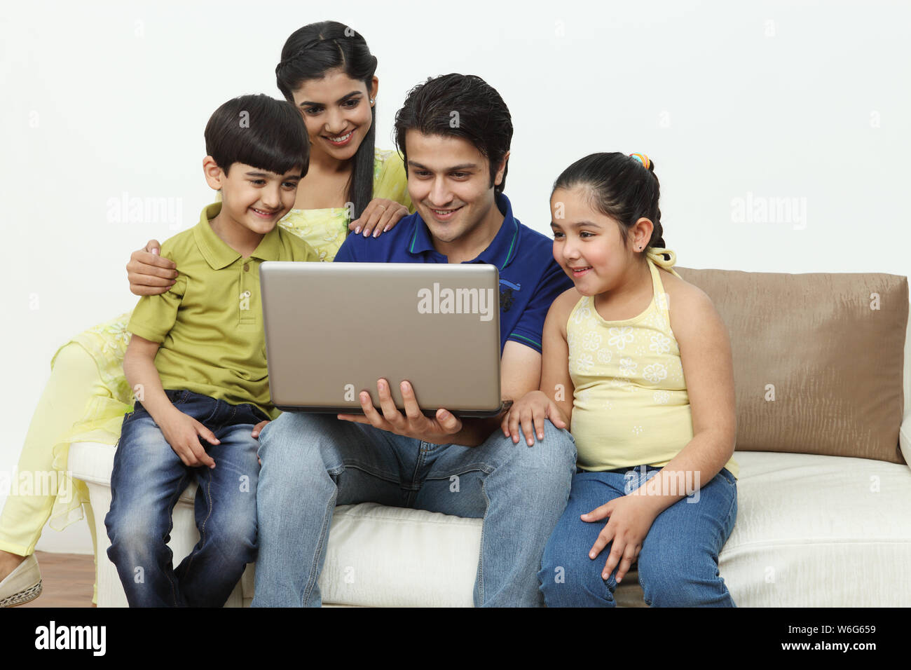 Family using laptop and smiling Stock Photo - Alamy