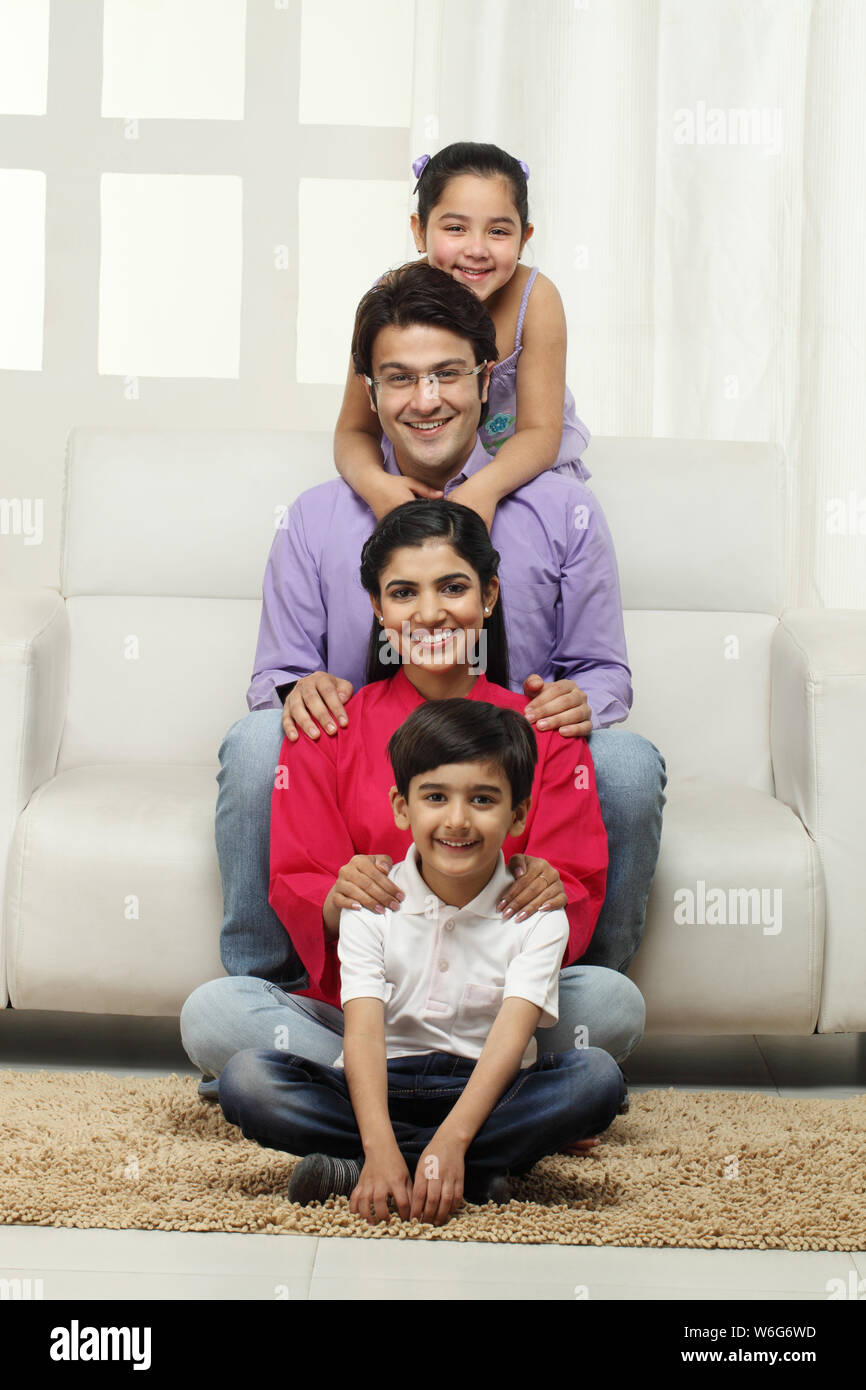 Family sitting in a row and smiling Stock Photo - Alamy