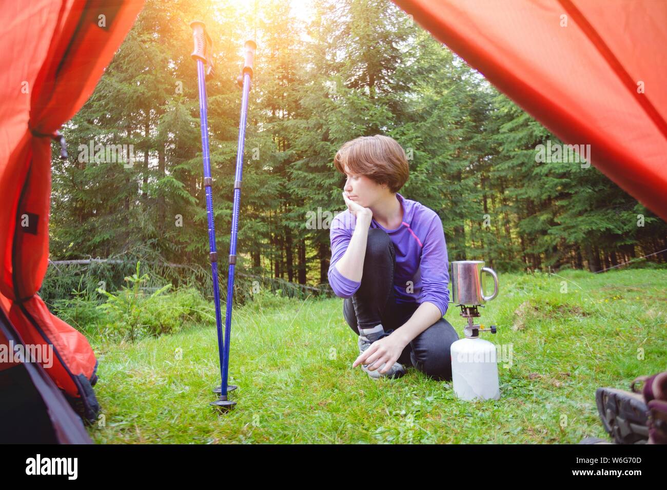 hike and camping life. view from the tent on tourist girl cooks food on ...