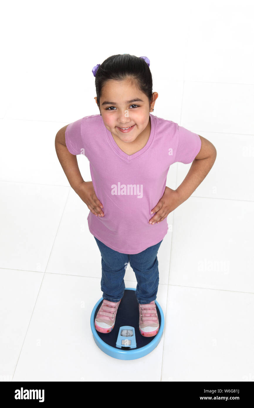 High angle view of a girl weighing herself on bathroom scale Stock ...