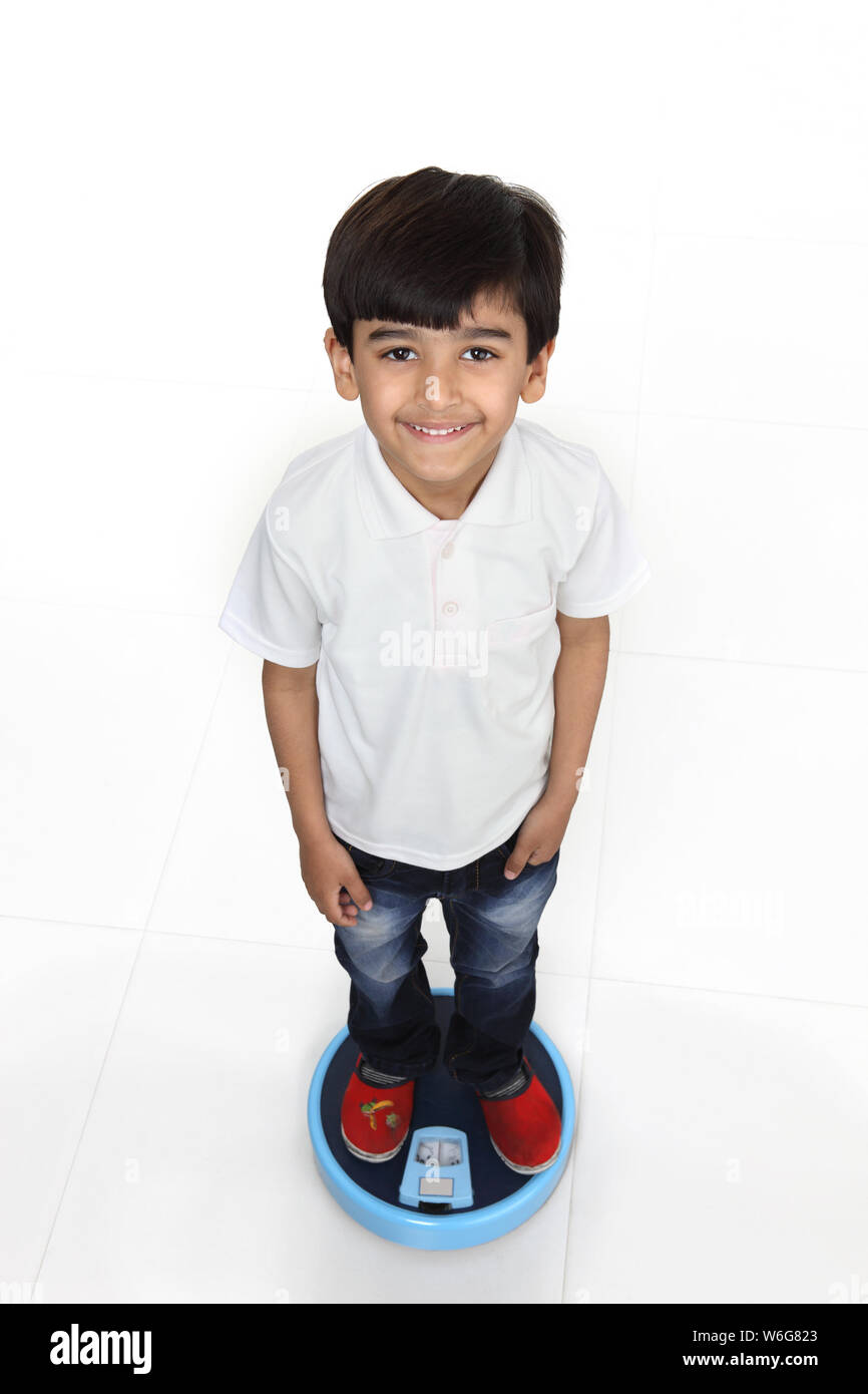 High angle view of a boy weighing himself on bathroom scale Stock Photo ...
