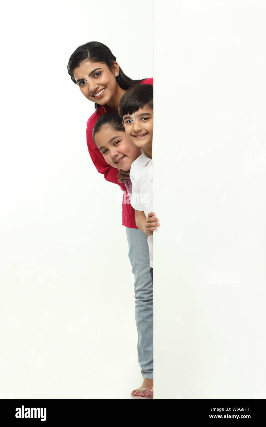 Family hiding behind a blank placard Stock Photo - Alamy