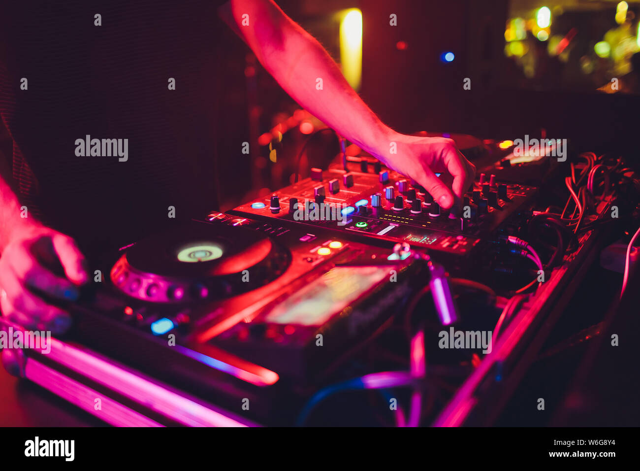 DJ turntable console mixer controlling with two hand in concert ...