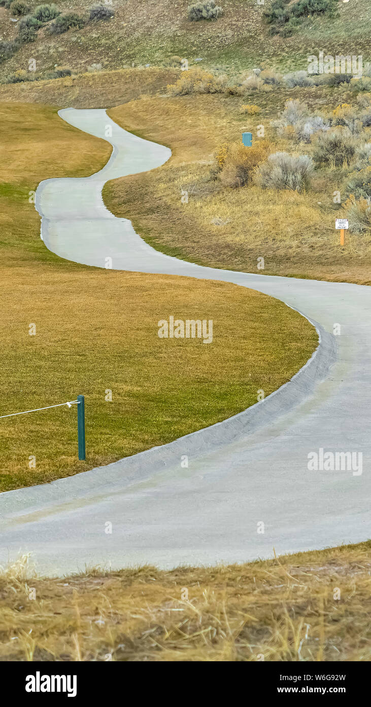 Vertical Narrow road paved with concrete and winding through the slope ...