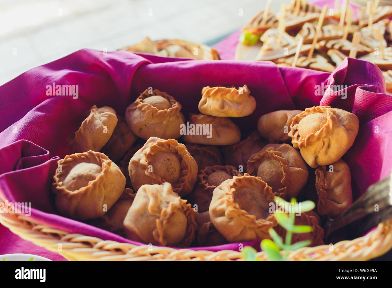 Homemade baked uchpuchmak samsa with meat and potato on a wooden plate ...