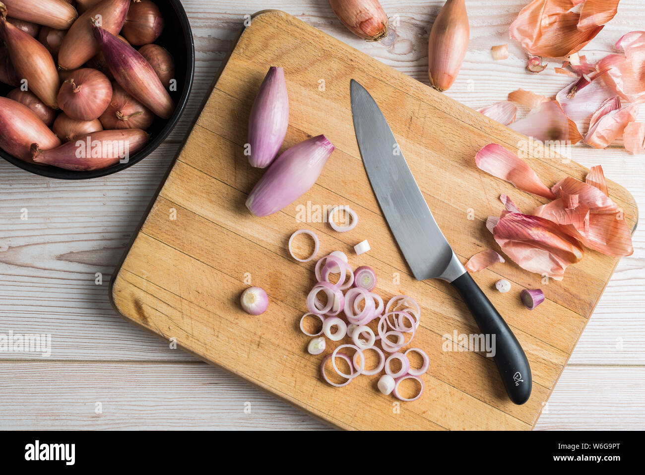 Banana and round shallots on a chopping board with a knife Stock Photo ...