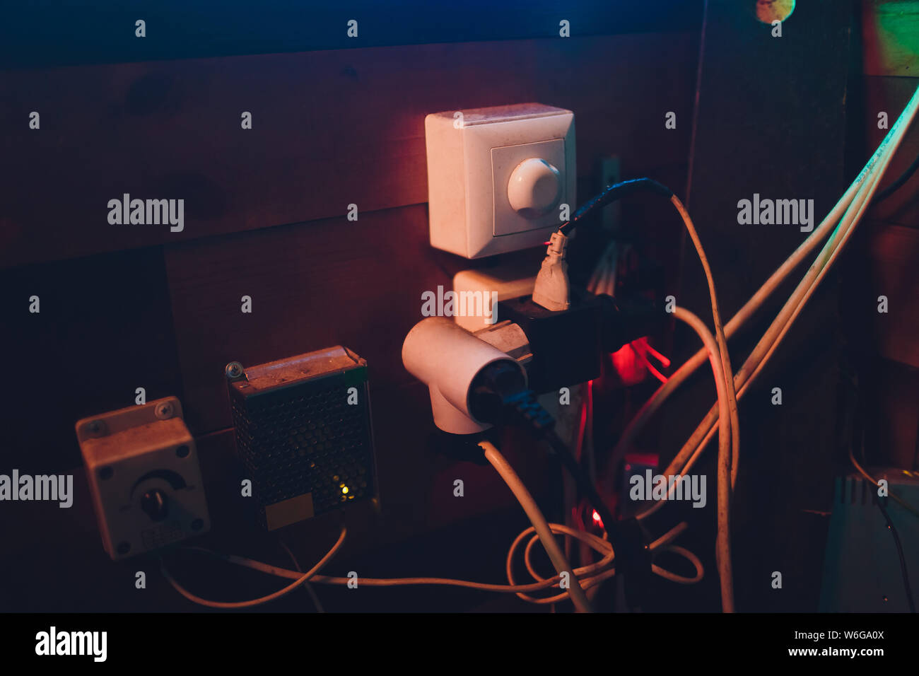 Multiple electrical plugs in wall outlet mixed up Stock Photo - Alamy