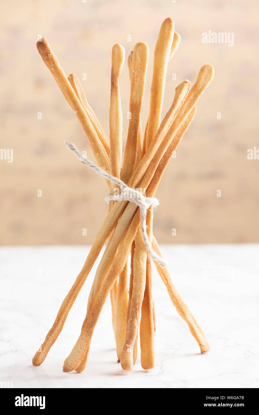 Rustic, home made bread sticks tied with coarse string in a bundle ...