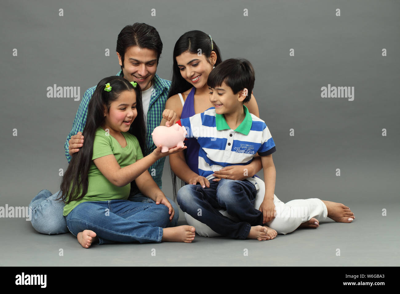 Boy with his sister saving with piggy bank Stock Photo - Alamy