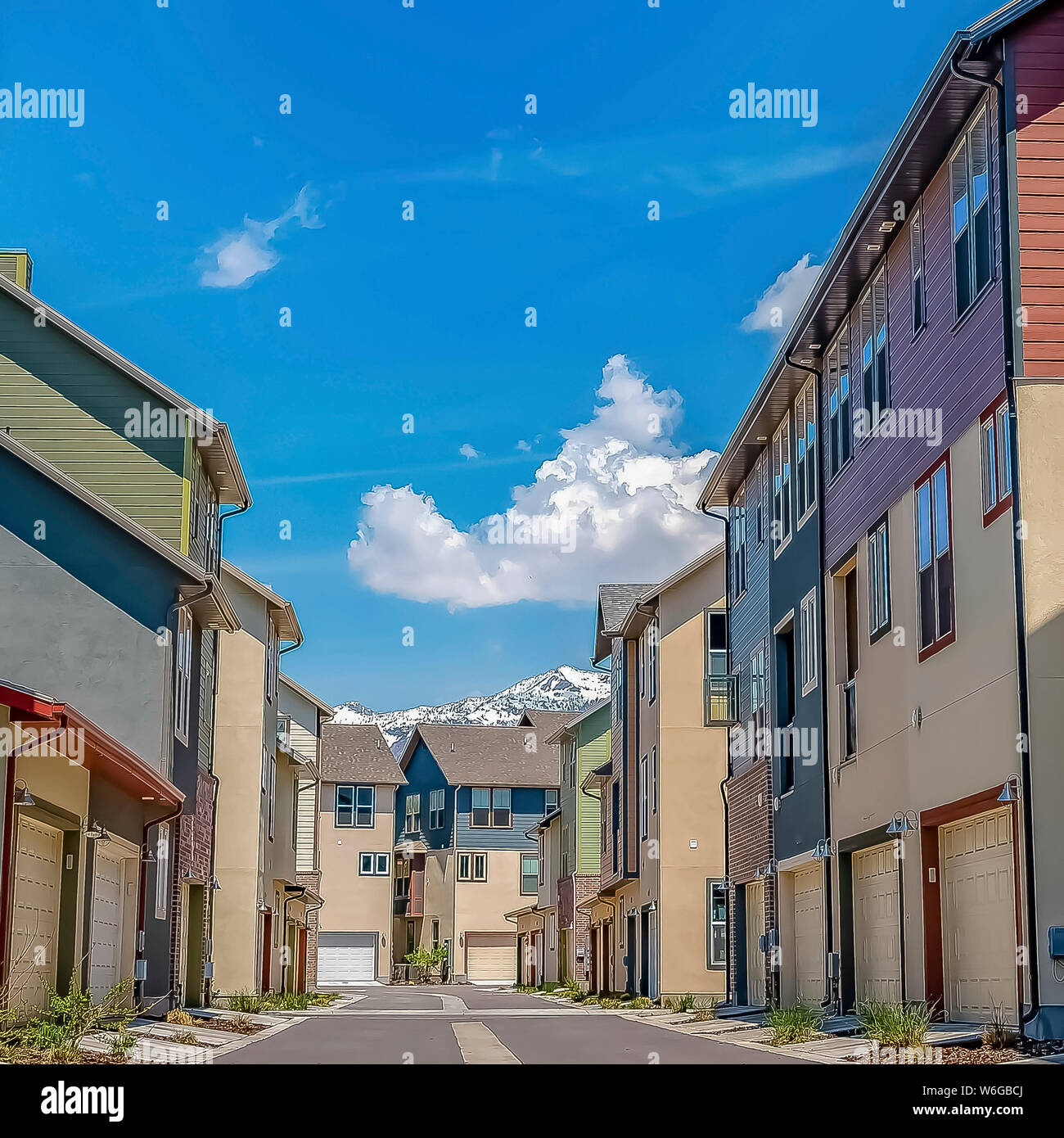 Square frame Rows of houses with paved road in the middle under blue ...