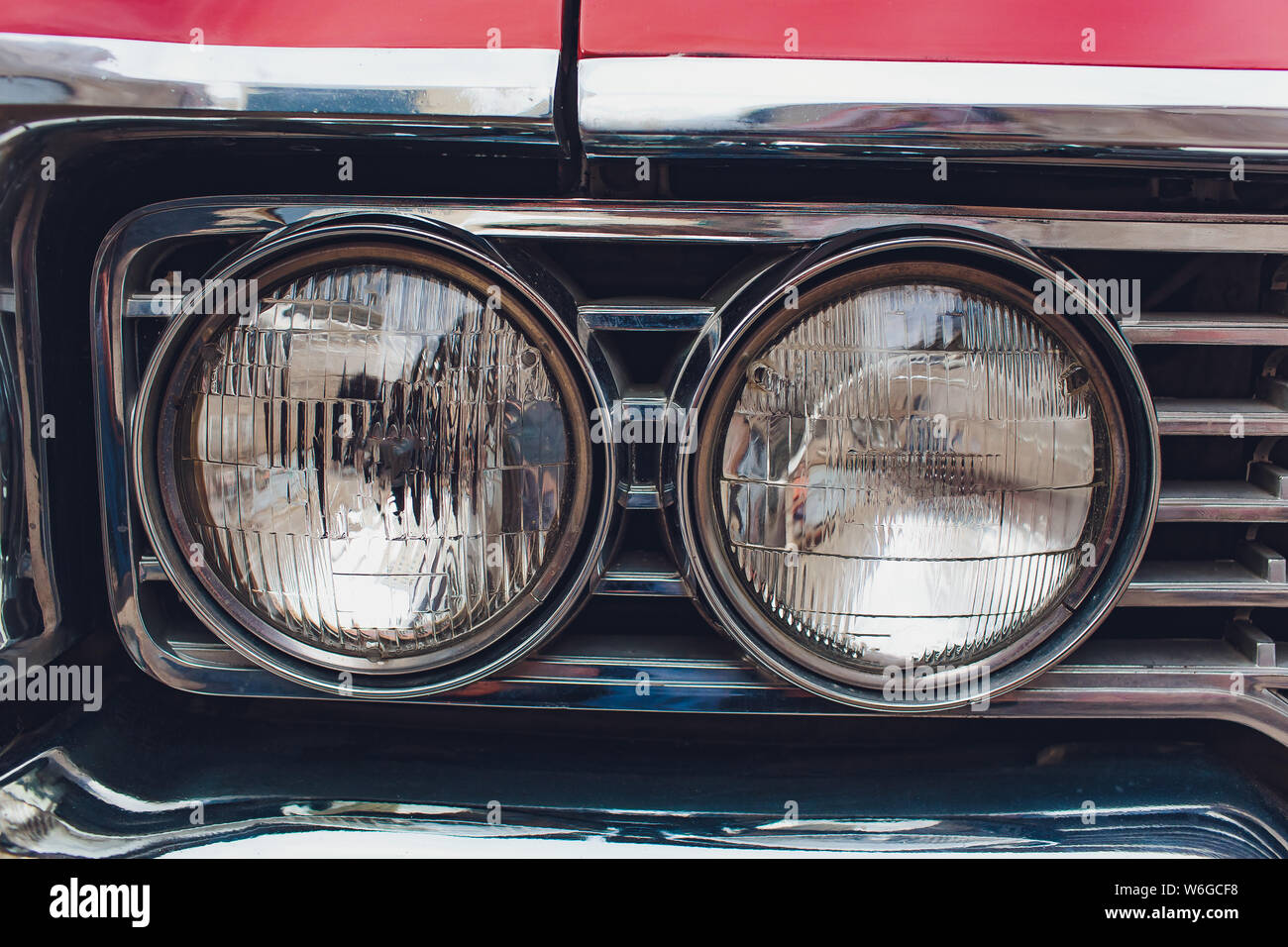 A closeup of the headlight and front bumper on a vintage car Stock ...