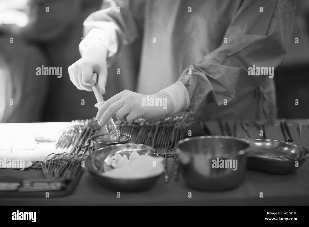 A surgical nurse picks up the solution in a syringe during surgery ...