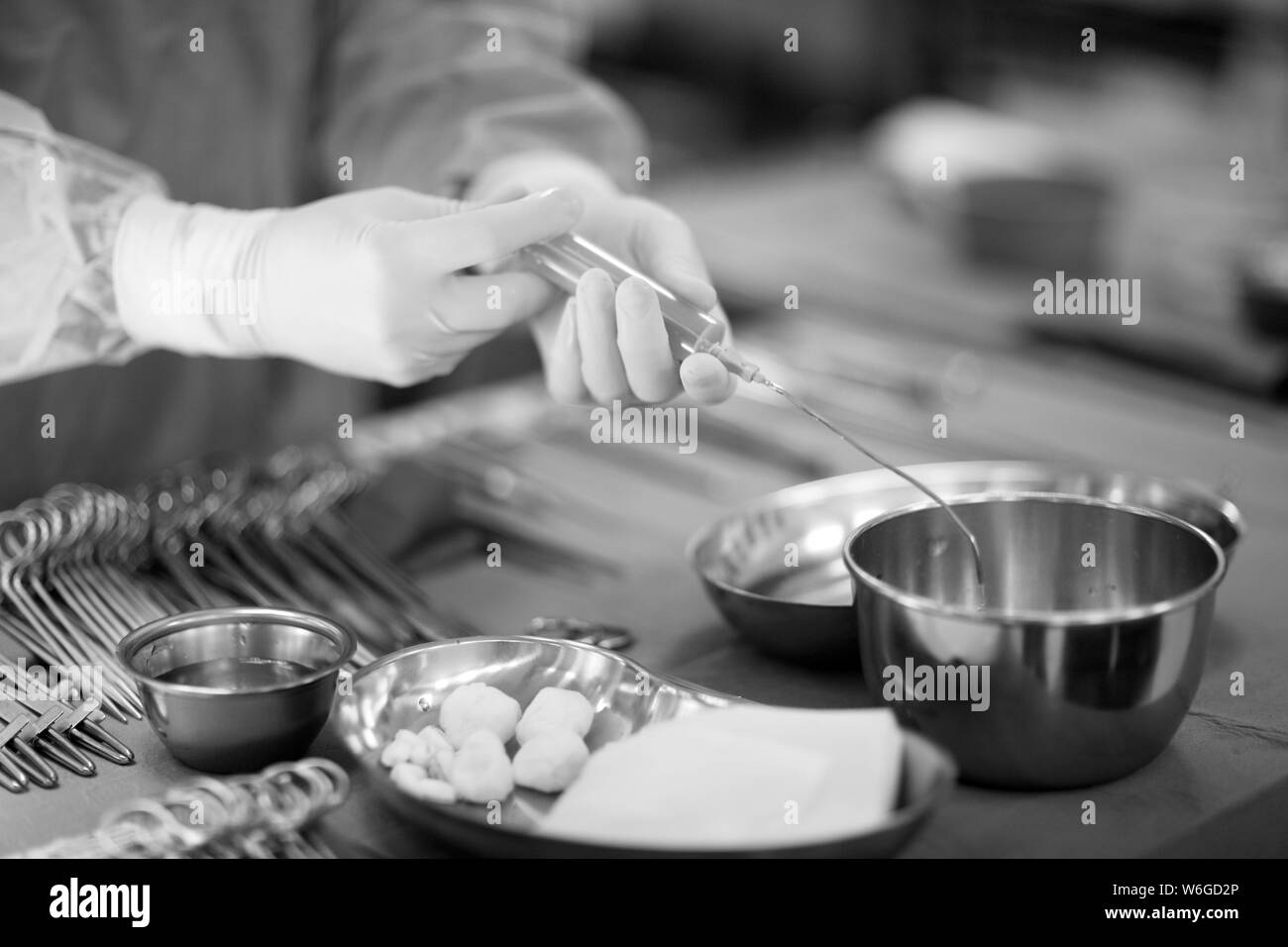 A surgical nurse picks up the solution in a syringe during surgery ...