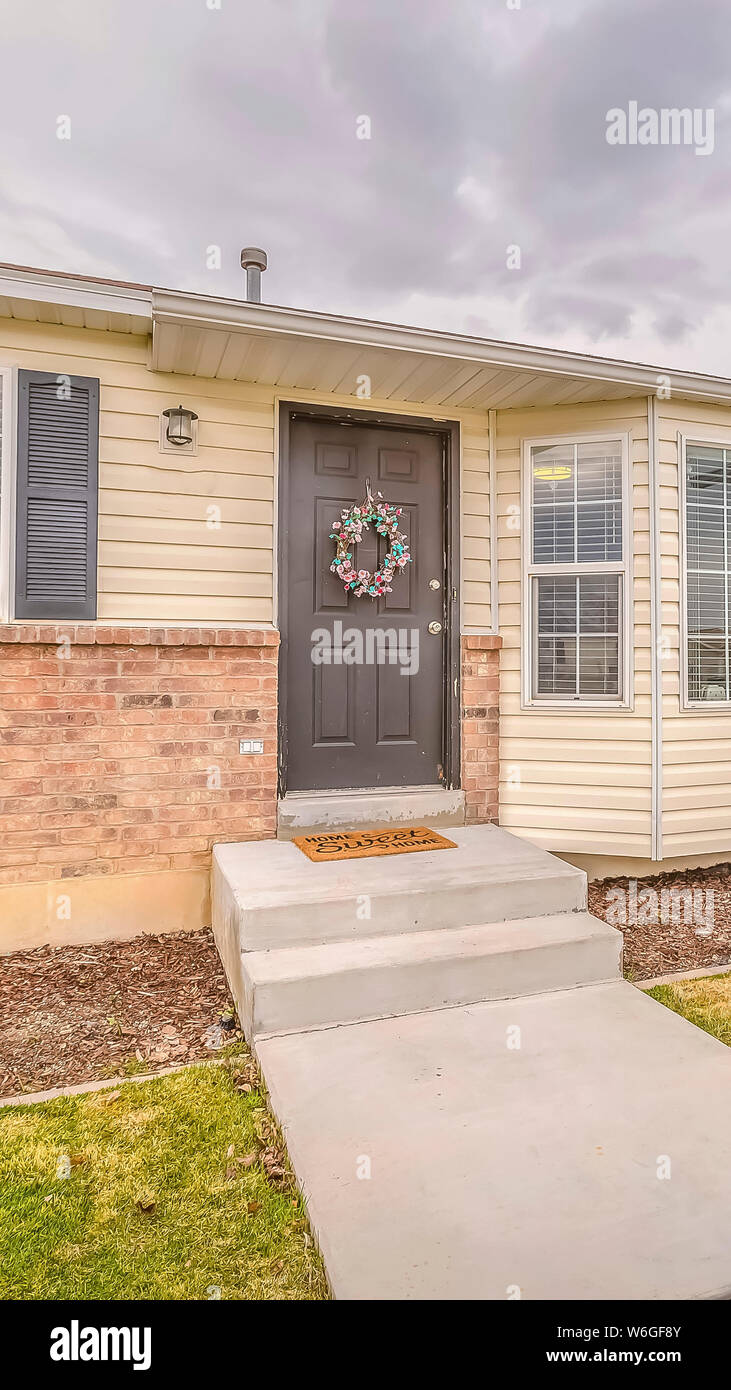 Vertical frame Facade of home with yard pathway and stairs in front of ...