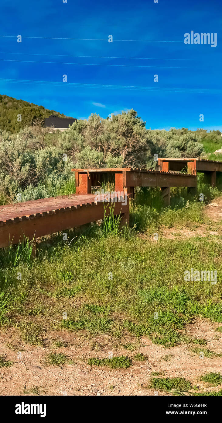 Vertical Elevated wooden bike tracks amid bushes and grasses on a hill ...