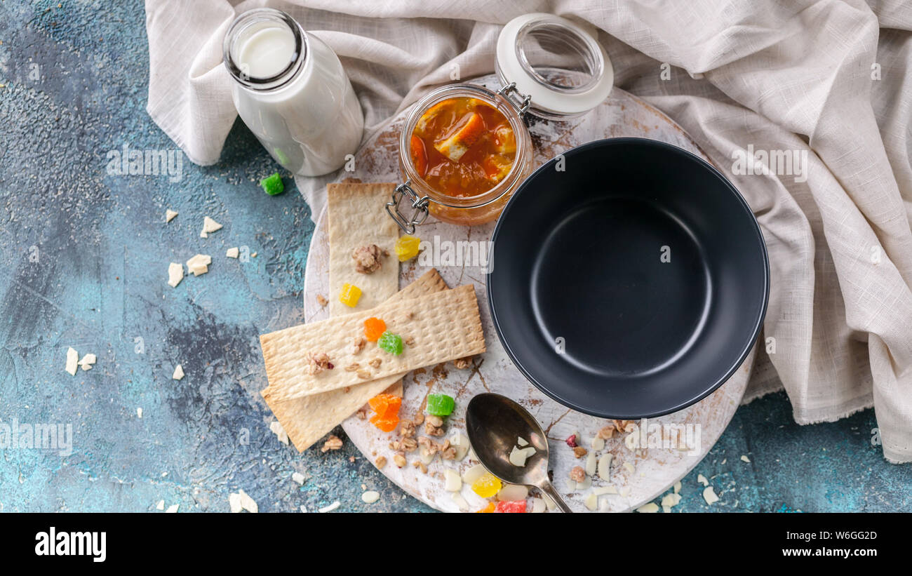 Food banner Empty dark bowl, candied fruit, orange jam and milk. Tasty ...