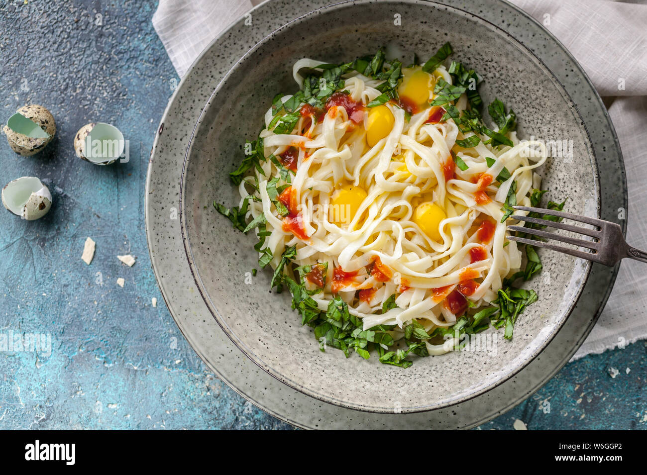 Top view traditional spaghetti with quail eggs and herbs. Mediterranean ...