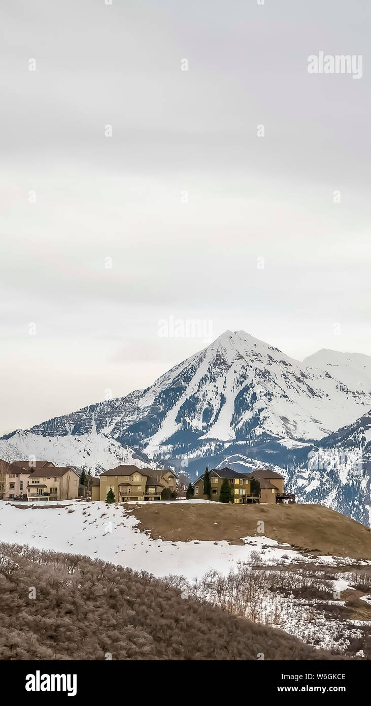 Vertical Hill with homes and snow overlooking a striking white peaked ...