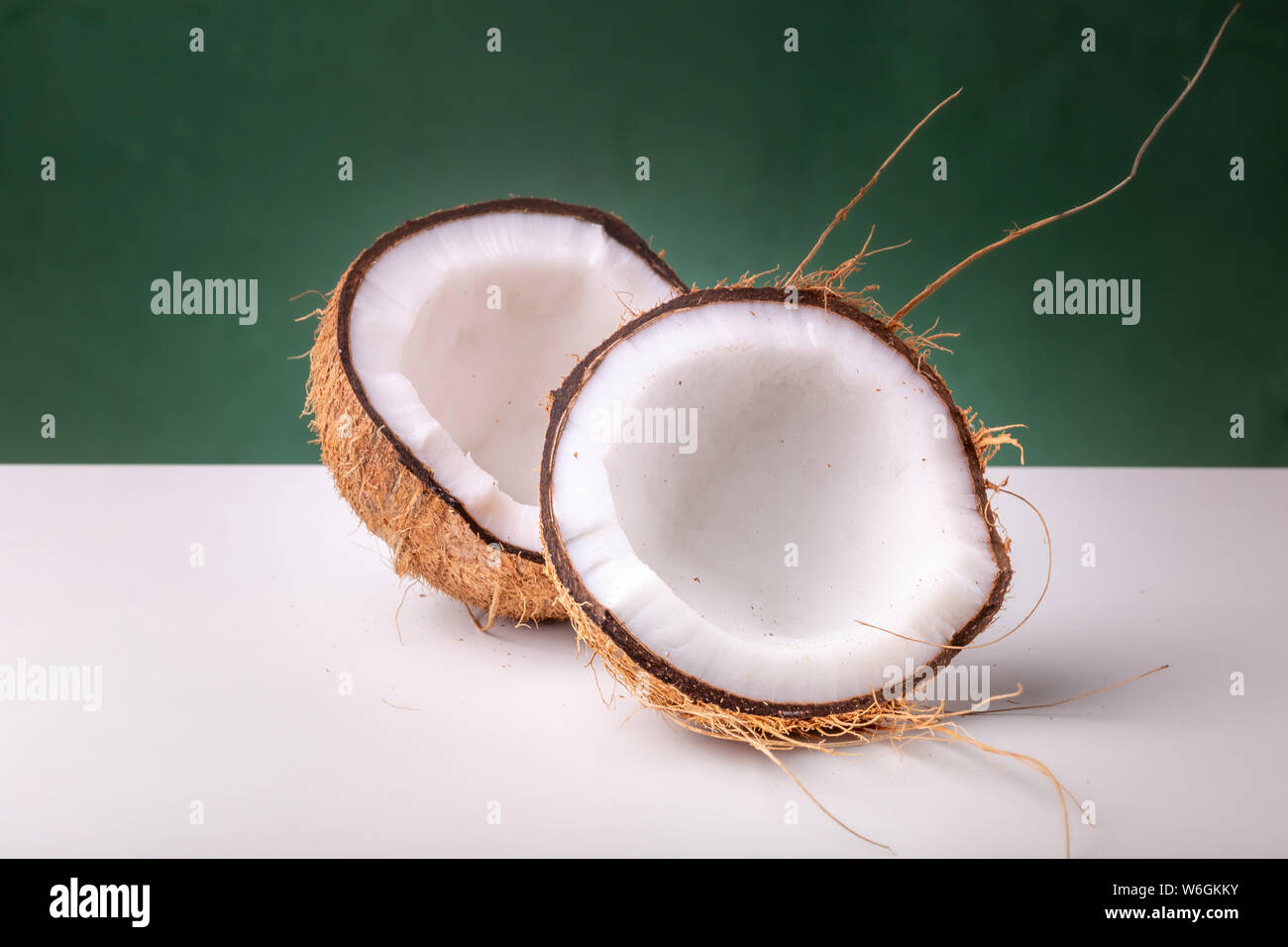 Two halves of a coconut with the brown outer shell and white coco ...