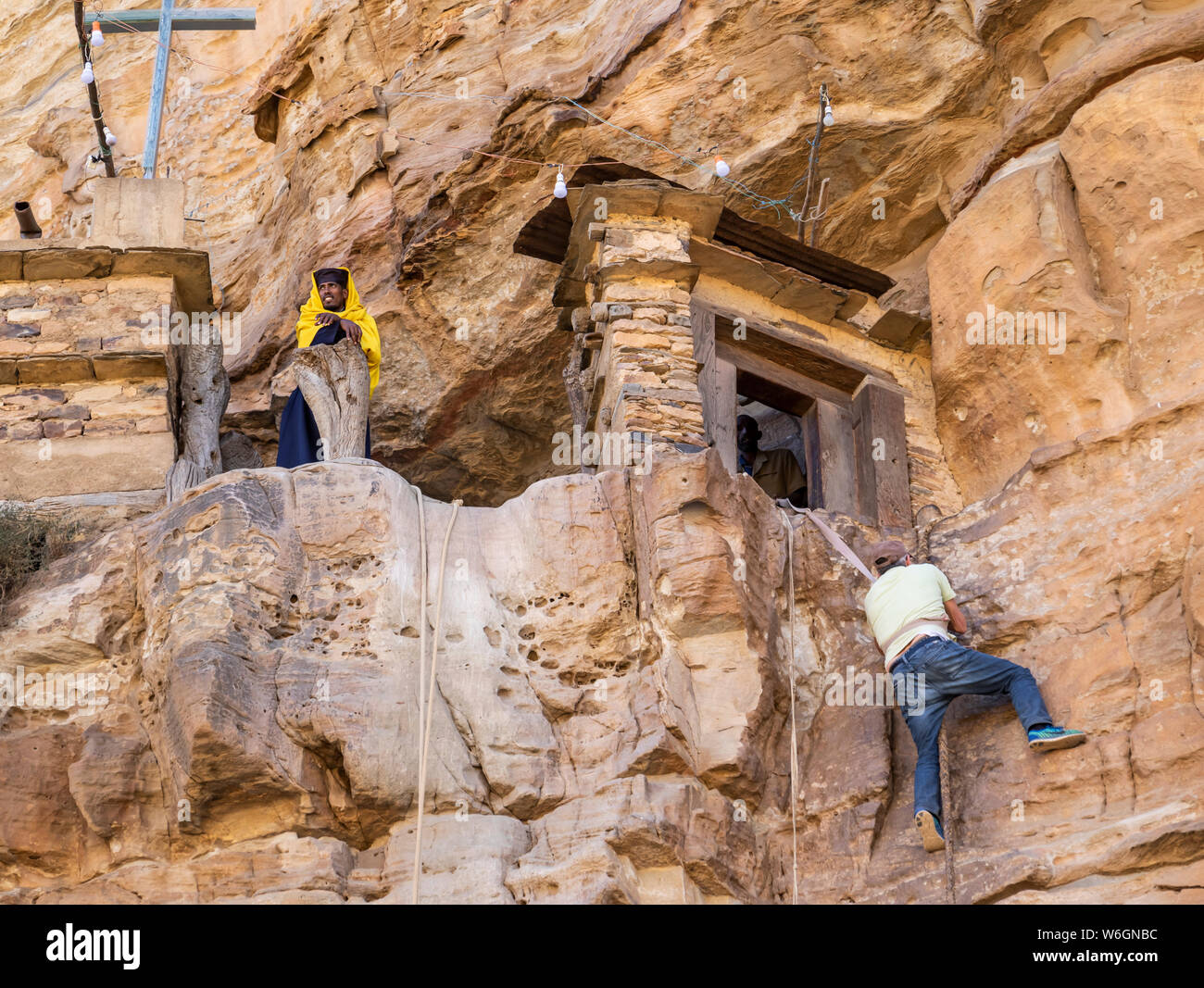 Man climbing on a rope to reach Debre Damo monastery; Tigray Region ...