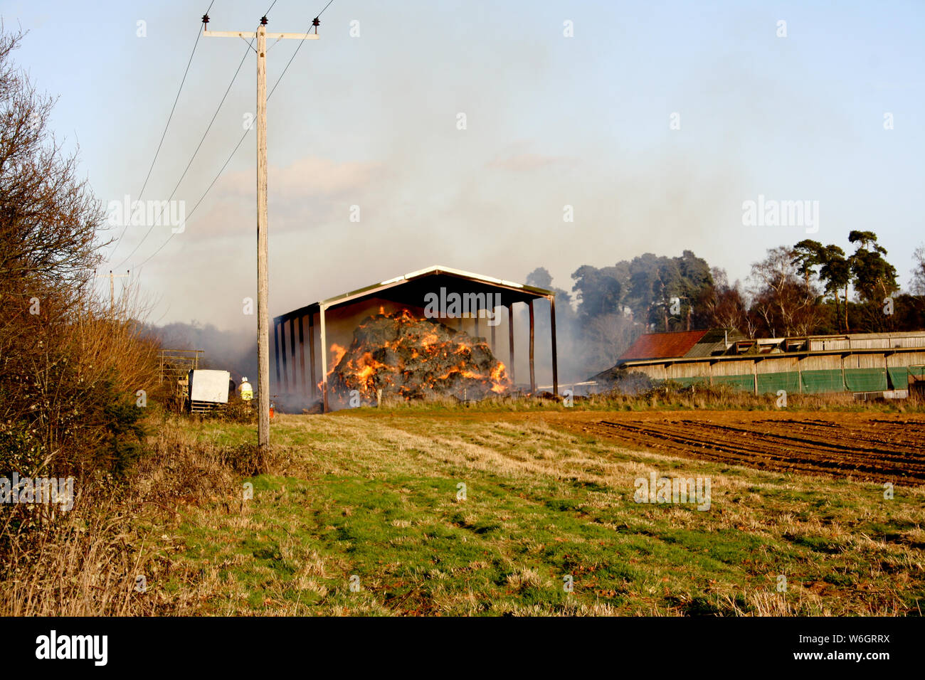 A tin roof barn with a harvest of hay which caught fire Stock Photo - Alamy