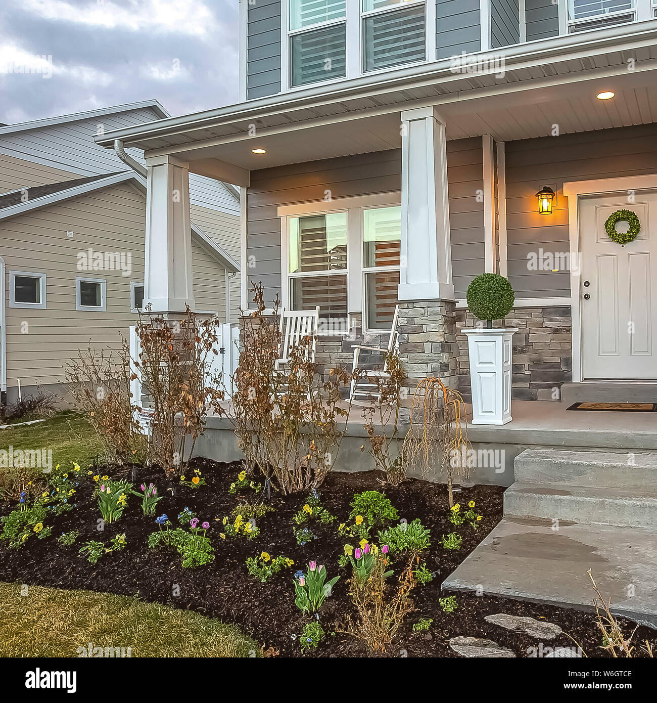 Square frame Porch and yard at the facade of a home with stairs leading ...