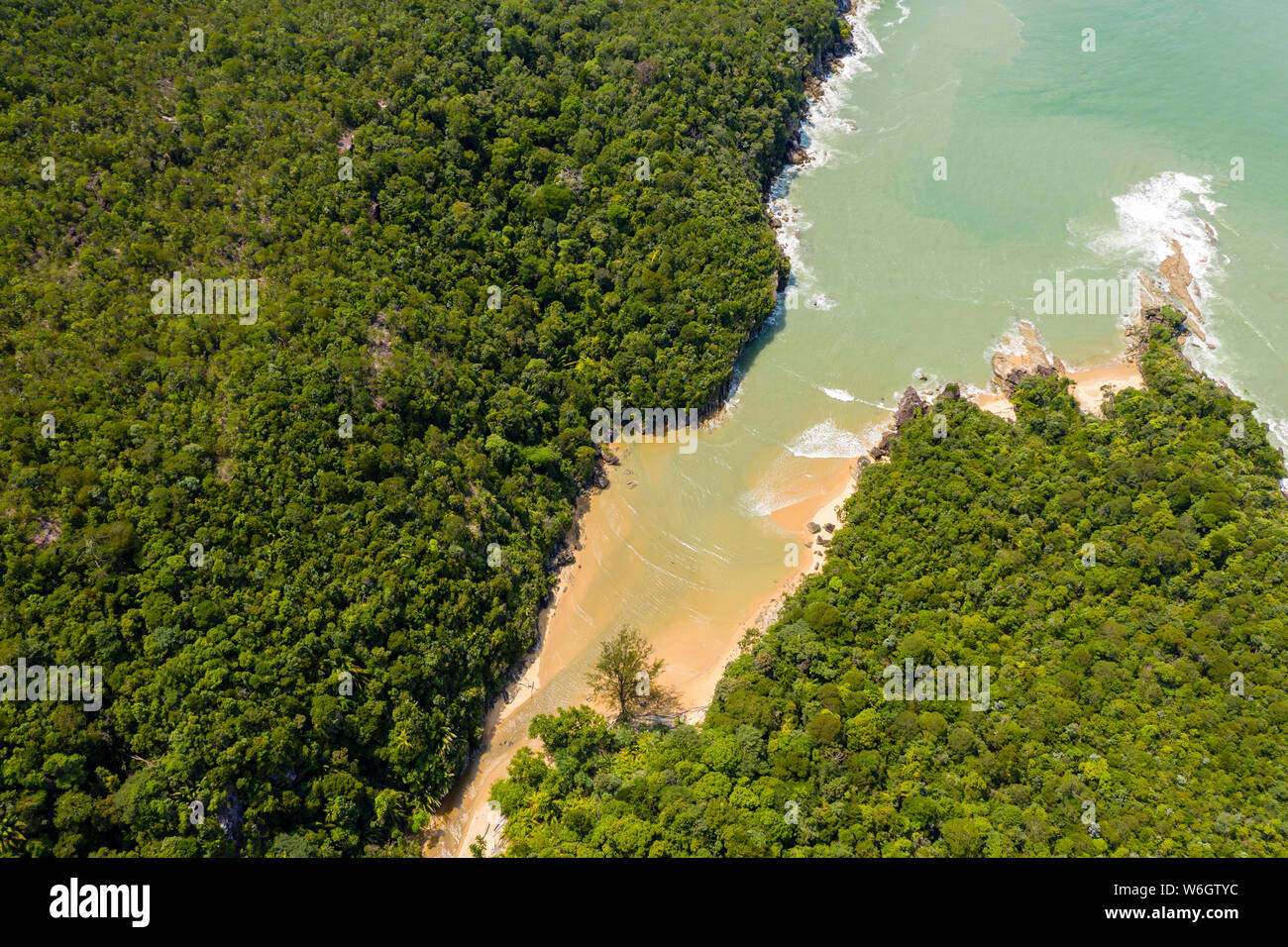 Aerial drone view of a deserted tropical sandy beach surrounded by ...