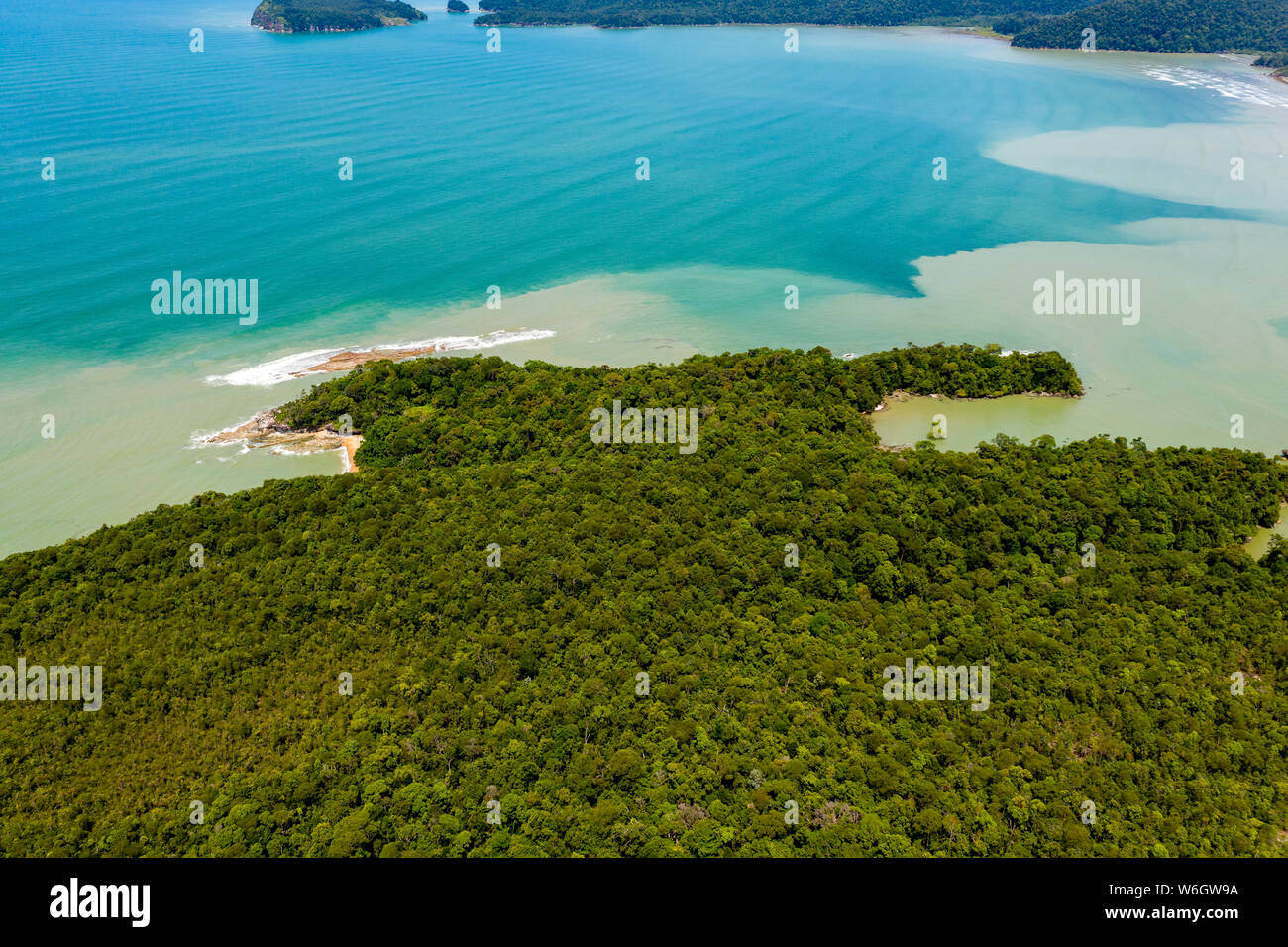 Aerial drone view of dense tropical rainforest leading to a remote ...