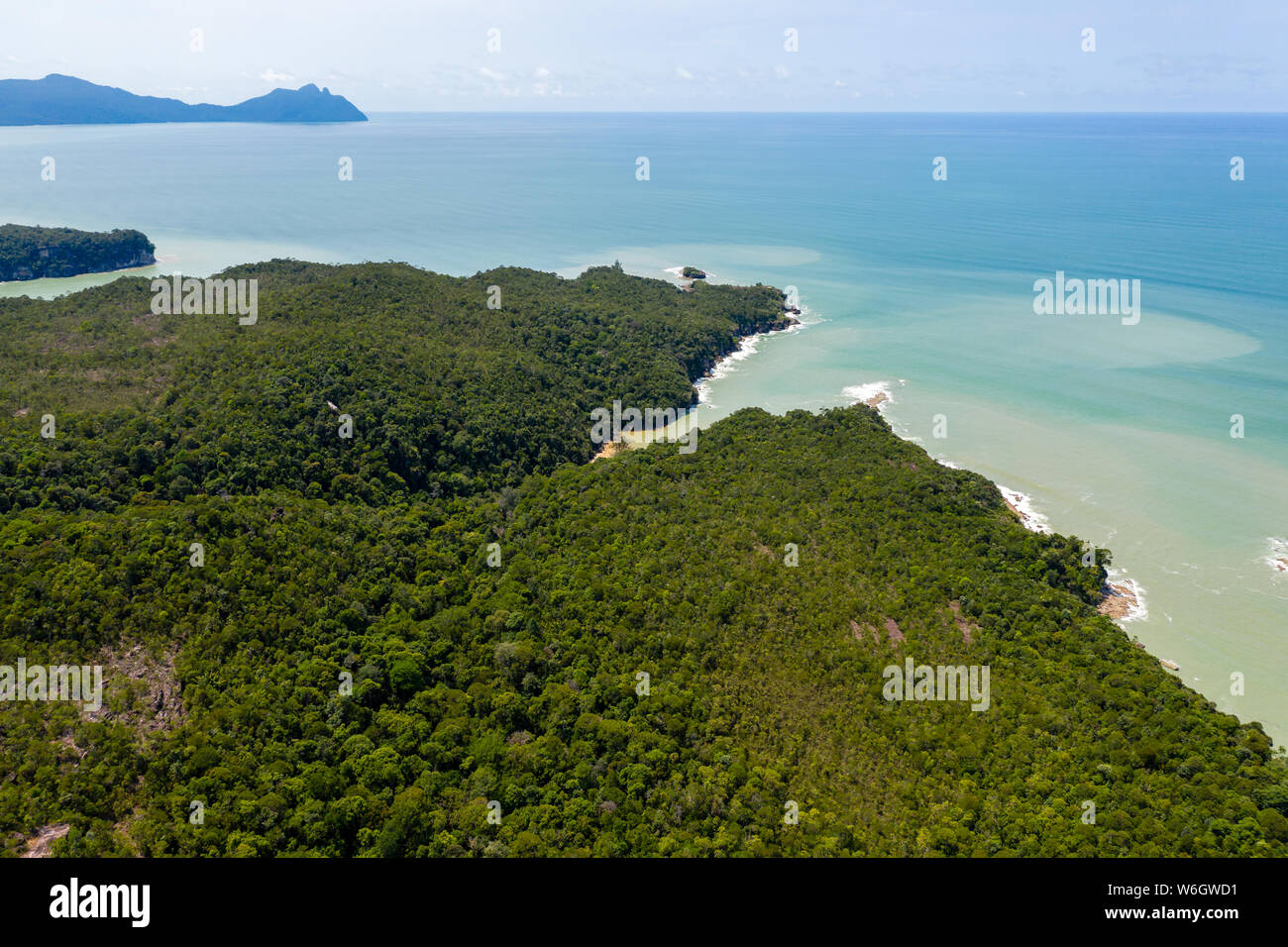 Aerial drone view of dense tropical rainforest leading to a remote ...
