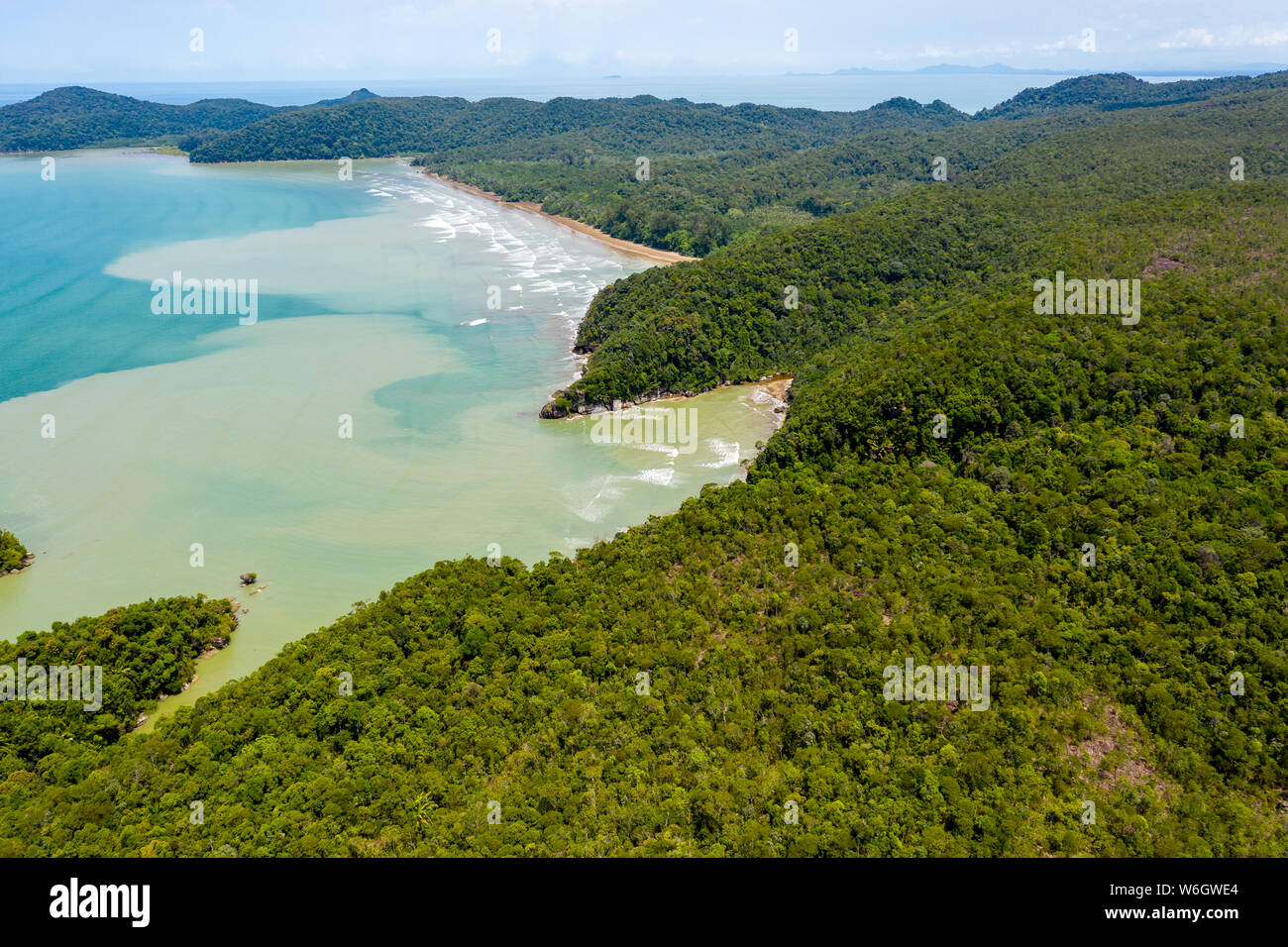 Aerial drone view of dense tropical rainforest leading to a remote ...