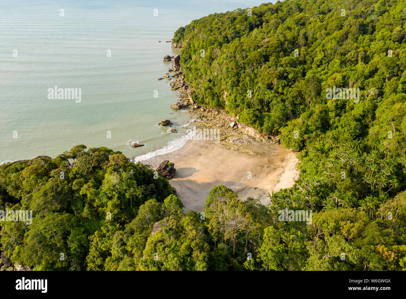 Aerial drone view of a beautiful small, deserted sandy beach in a small ...