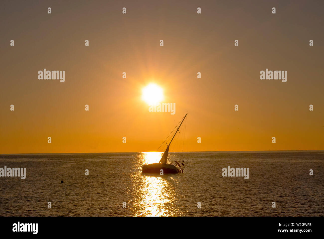 Sunrise over the Red Sea and the silhouette of an abandoned boat in ...