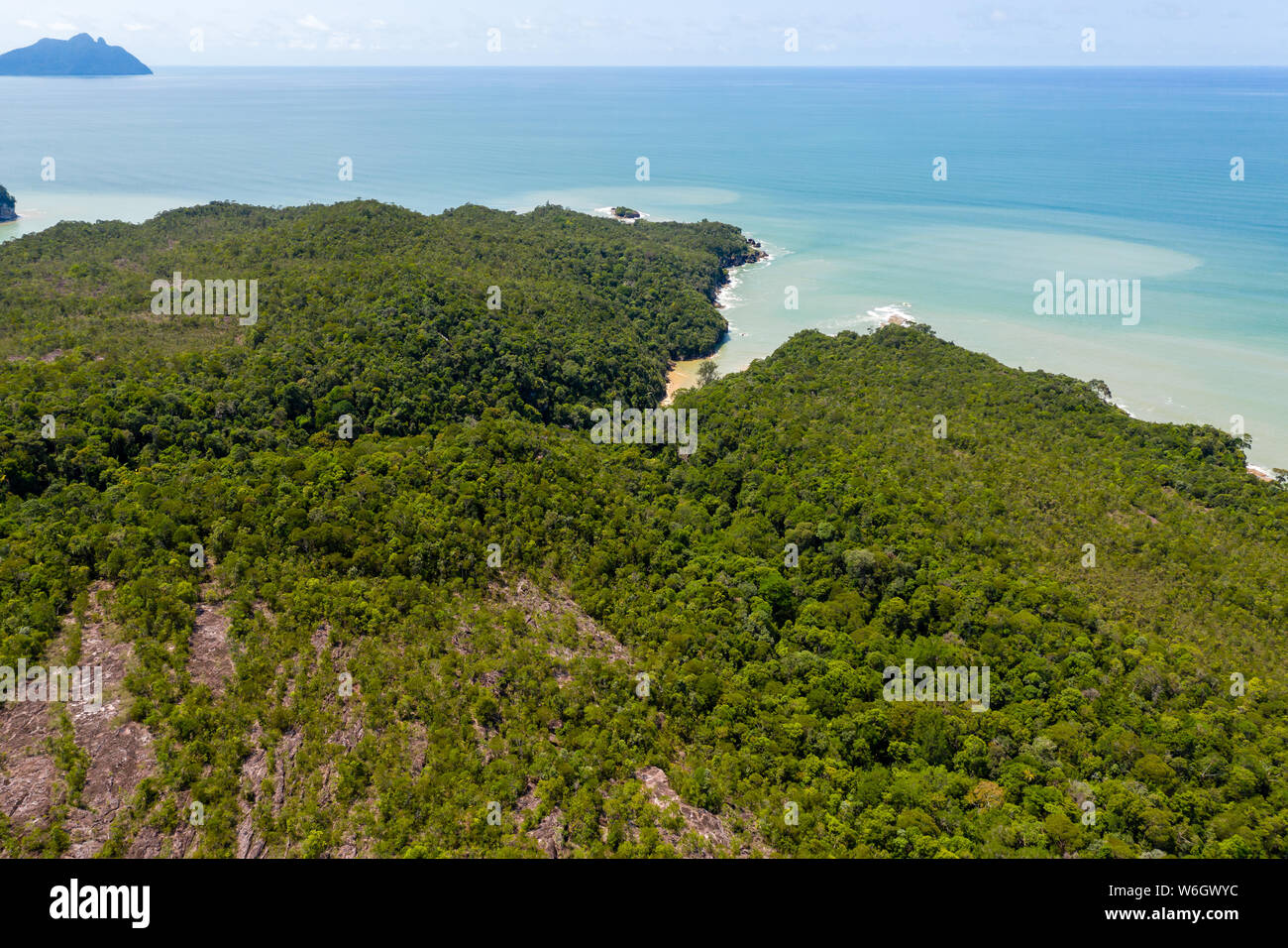 Aerial drone view of dense tropical rainforest leading to a remote ...
