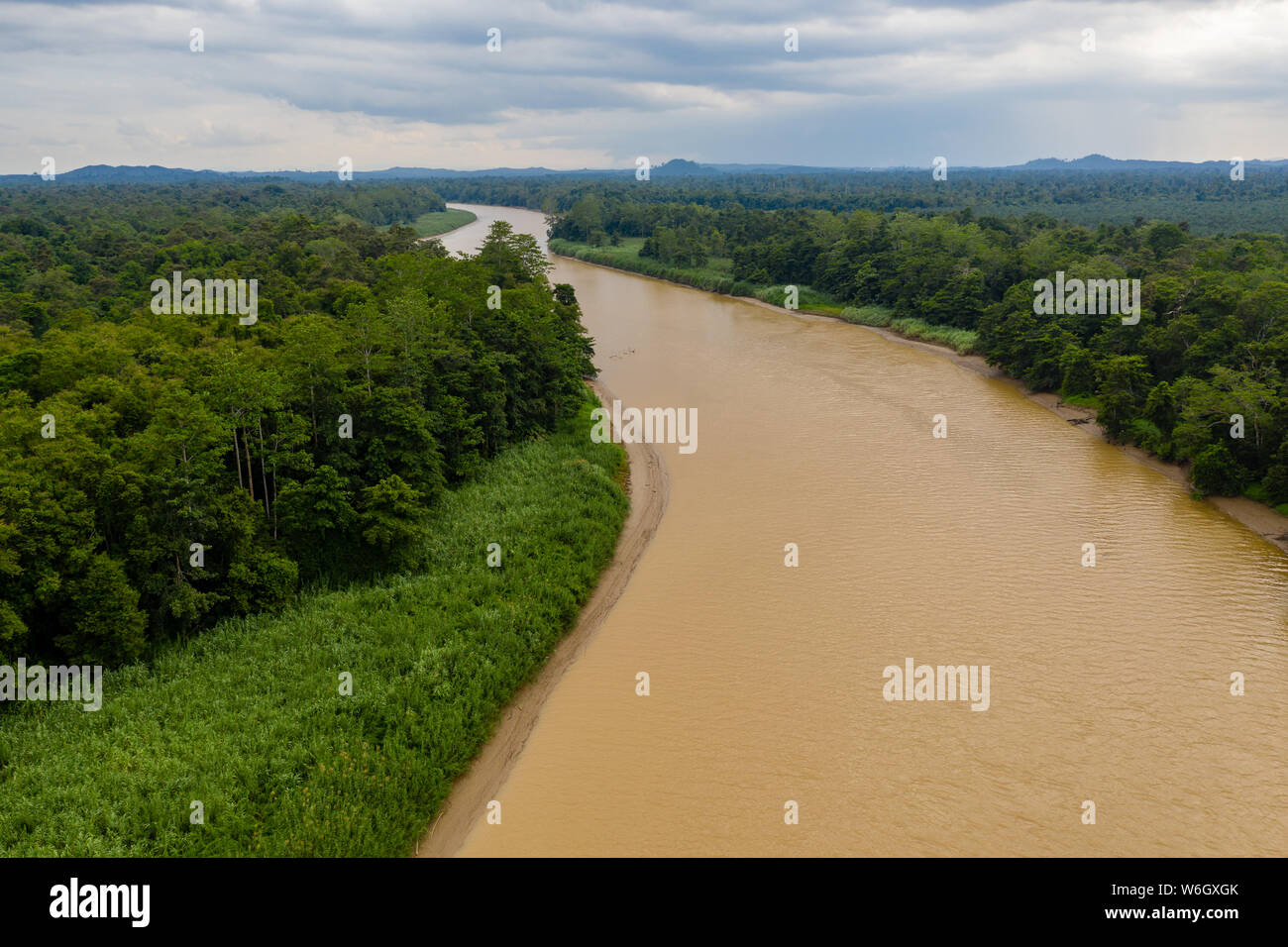 Aerial drone view of a long winding river through a tropical rain ...