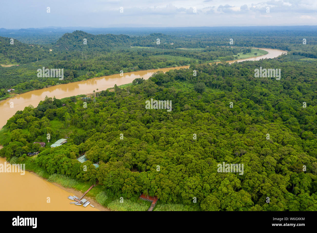 Aerial drone view of a long winding river through a tropical rain ...