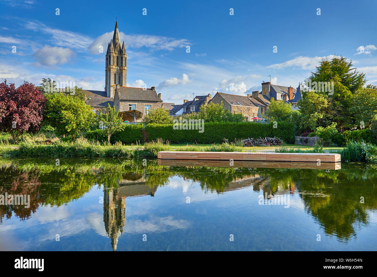 Image of Evran, France from the canal with the reflection of Eglise ...