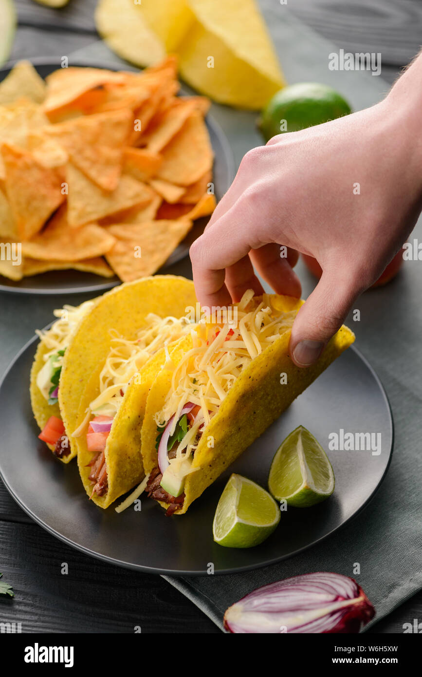 Hand taking a hard-shell taco Stock Photo - Alamy